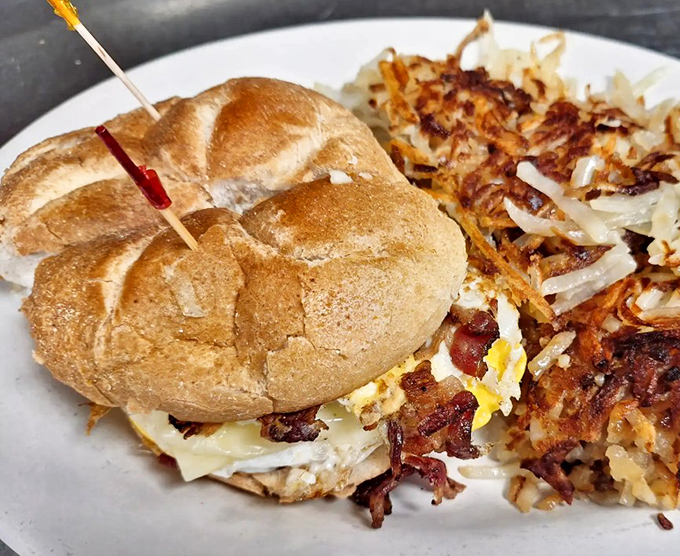 Breakfast architecture at its finest&mdash;a perfectly constructed sandwich with crispy bacon and melty cheese, alongside hash browns that mean business.