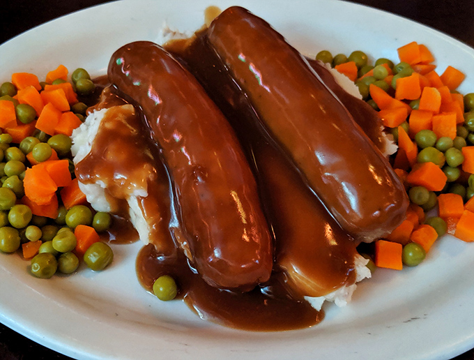 These bangers have more snap than a Florida gator, nestled in cloud-like mashed potatoes and swimming in gravy that deserves its own fan club.