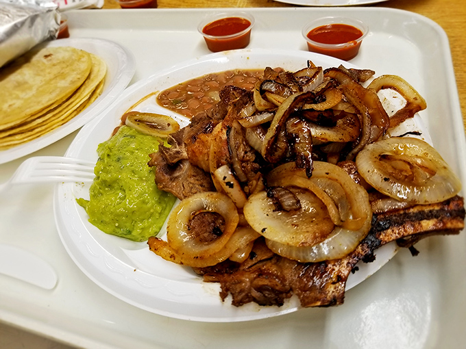 This isn't just steak—it's a masterclass in flame-kissed perfection. Those caramelized onions and side of guacamole aren't accessories; they're essential supporting characters.