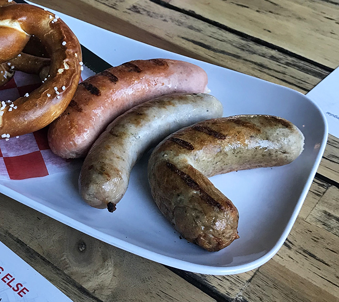 A trio of sausages with a fresh pretzel&mdash;the kind of plate that makes you wonder why you ever bothered with those sad boiled hot dogs.