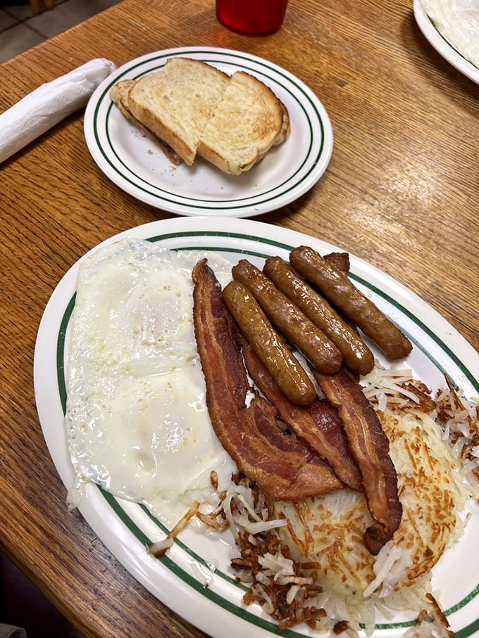 Breakfast perfection on a plate: eggs, sausage, bacon, and hash browns. The kind of morning fuel that makes you wonder why anyone bothers with avocado toast.