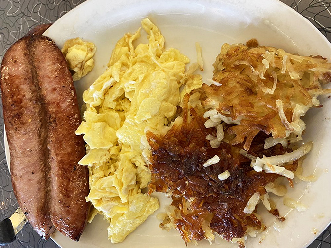 Breakfast nirvana achieved: perfectly scrambled eggs, sausage links with just the right snap, and hash browns crisped to golden-brown perfection.