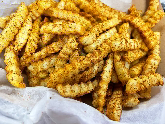 These seasoned crinkle-cut fries arrive dressed to impress &ndash; each one wearing its spices like a golden tuxedo.