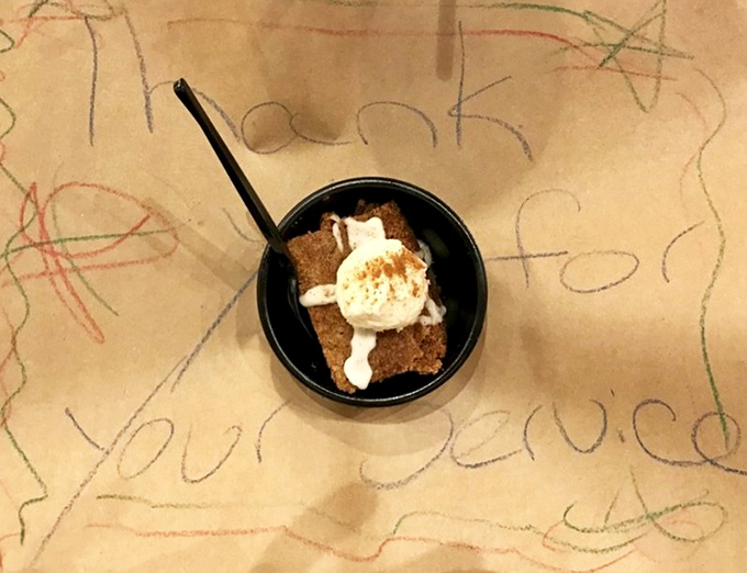 The carrot cake arrives like a humble hero, its cream cheese frosting melting slightly under the spotlight—a sweet finale worth every calorie-laden bite.