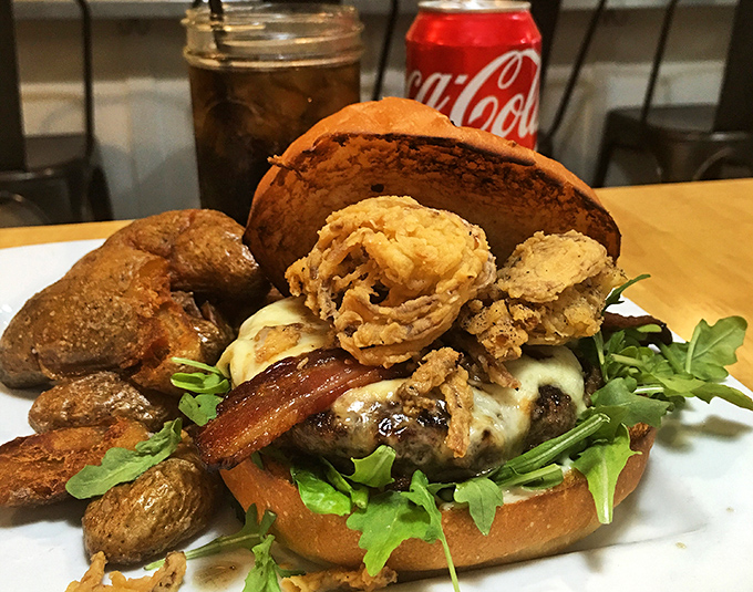 Not your average burger—this towering creation comes with crispy potatoes that make French fries look like they're not even trying.