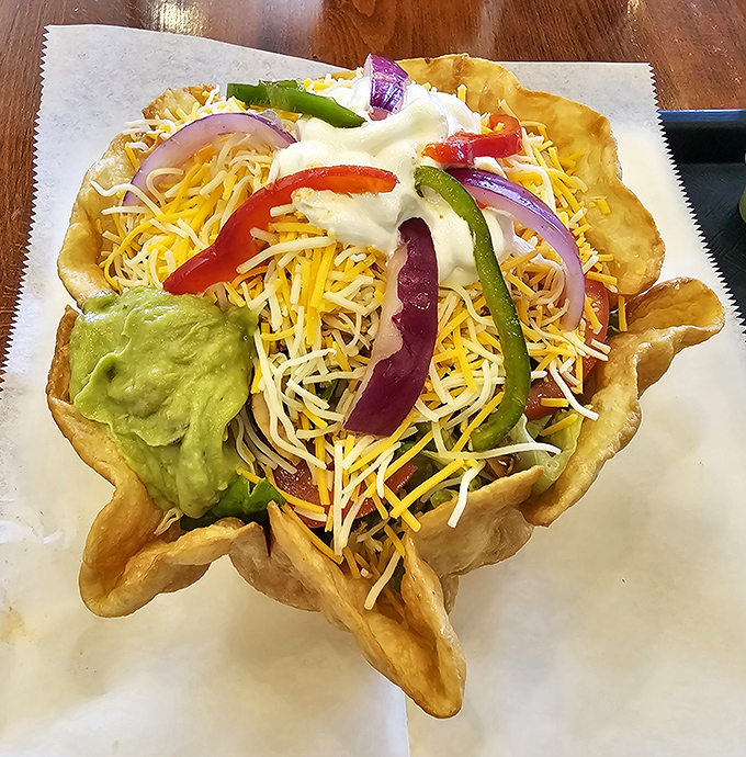 This isn't just a taco salad; it's an edible work of art. The crispy shell cradles a mountain of ingredients like a tortilla hammock of happiness.