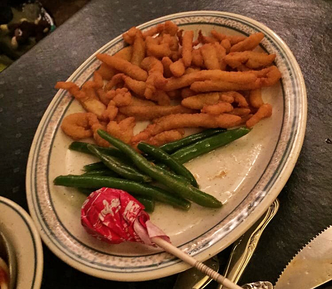 Golden-brown steak fries and crisp green beans share the spotlight with a lollipop-red garnish—comfort food dressed for a night out.