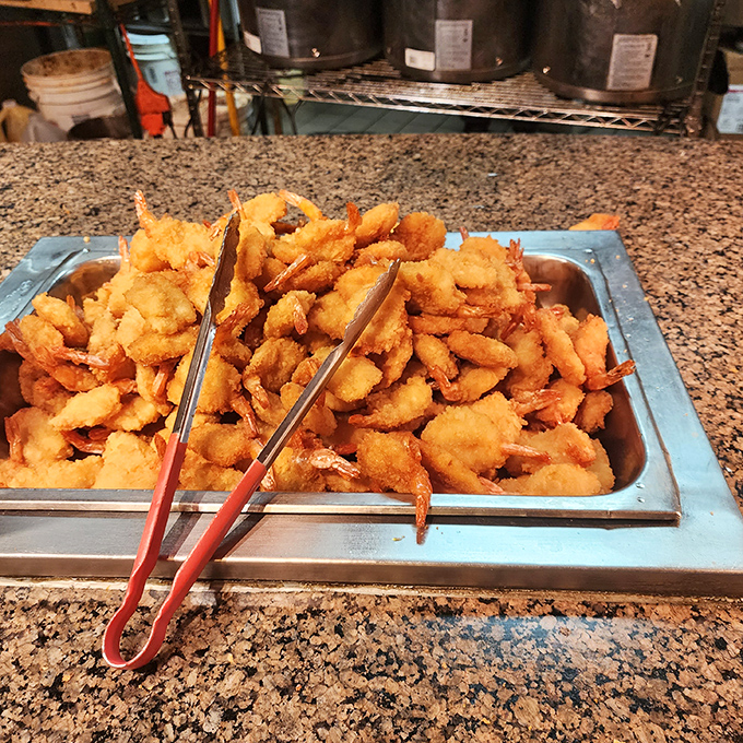 Golden-battered shrimp piled high like delicious treasure. These crispy crustaceans are what buffet dreams are made of&mdash;grab them before they disappear!