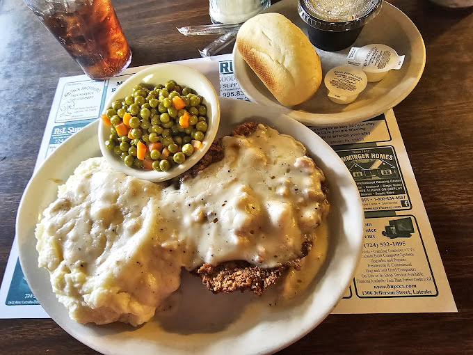 Country fried steak with mashed potatoes and peas—the holy trinity of comfort food that makes you forget about your diet faster than you can say "gravy."