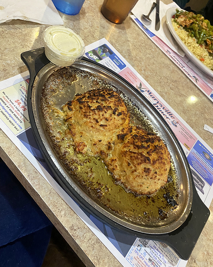 These golden-brown crab cakes sizzling in butter are the kind of simple perfection that makes you wonder why anyone bothers with fancy food.