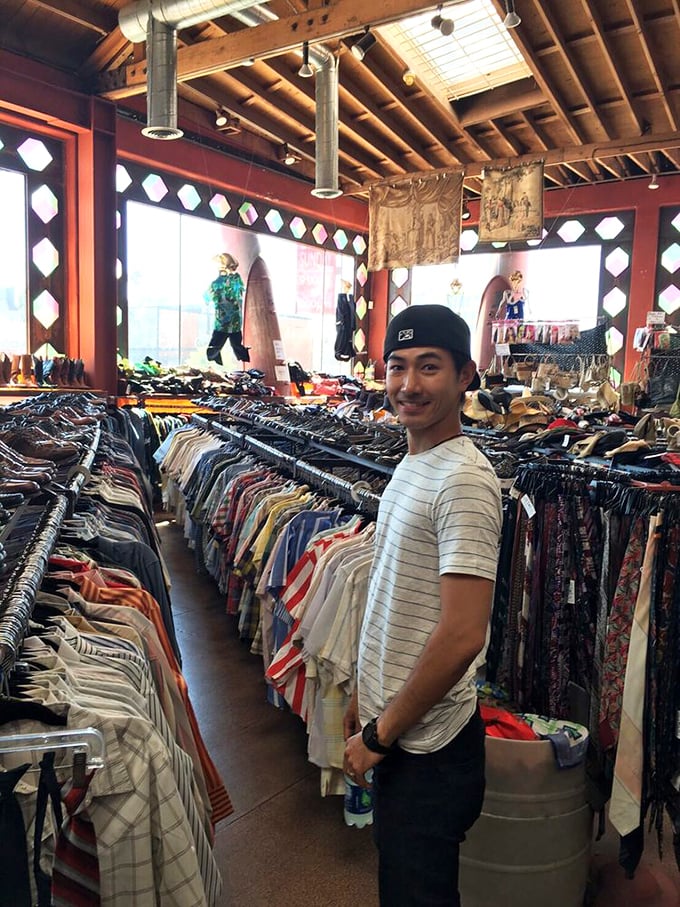 A dedicated treasure hunter demonstrates the proper thrift shopping stance: focused, determined, and slightly overwhelmed.