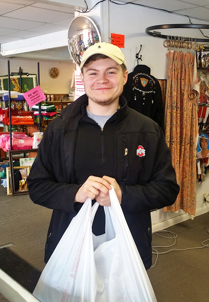 The universal thrift store victory pose – white bags filled with treasures and that unmistakable smile that says, "You won't believe what I found."