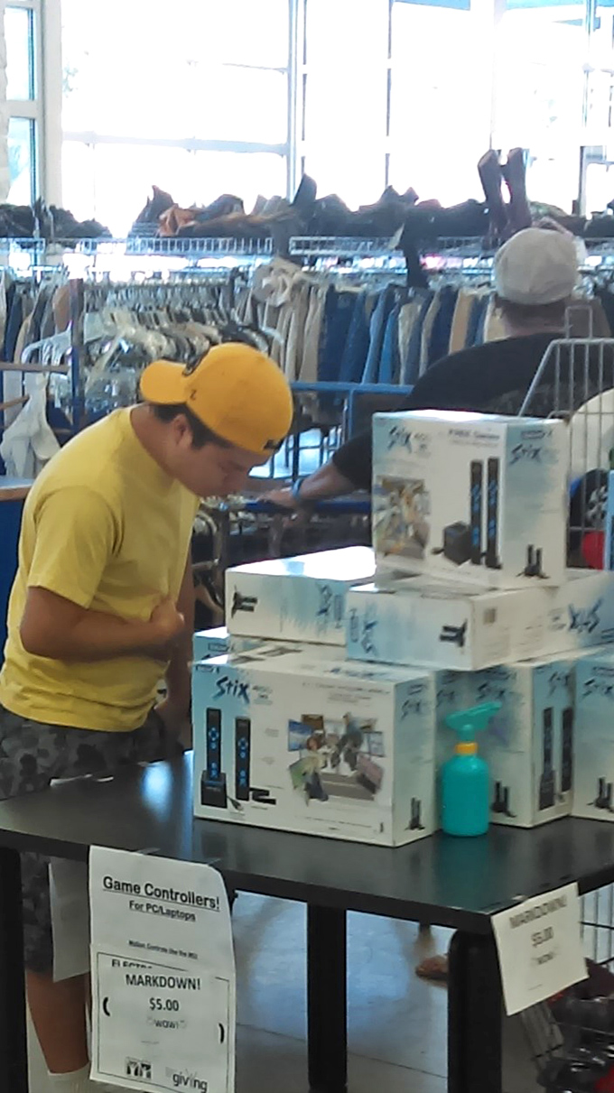 Electronics treasure hunting in action! Like archaeologists uncovering ancient gaming artifacts, shoppers dig for technological gold among yesterday's must-haves.