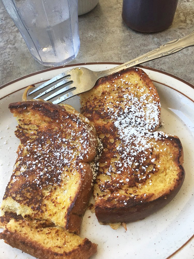 French toast arrives golden and dusted with powdered sugar, transforming ordinary mornings into something absolutely extraordinary.