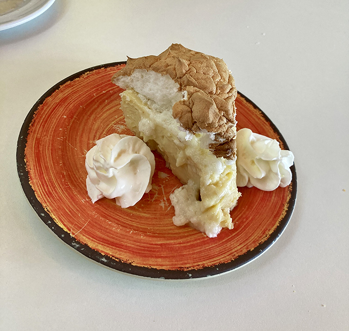 Key lime pie so authentic it should come with its own Florida citizenship papers, flanked by dollops of whipped cream standing guard.