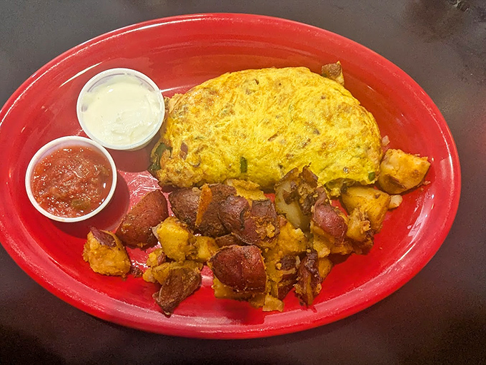 The Western omelet arrives like a sunrise on a red plate&mdash;fluffy eggs cradling peppers and cheese with home fries that could make a potato farmer weep with pride.
