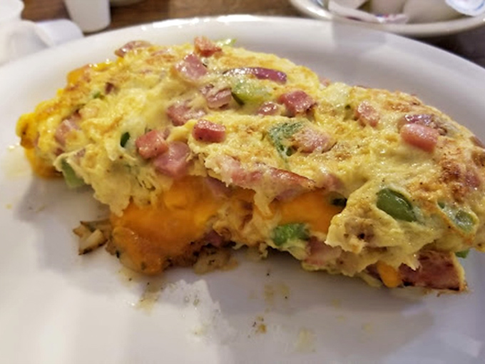 The perfect omelet reveals itself: a fluffy exterior giving way to melty cheese and ham treasures within. Morning alchemy at its finest.