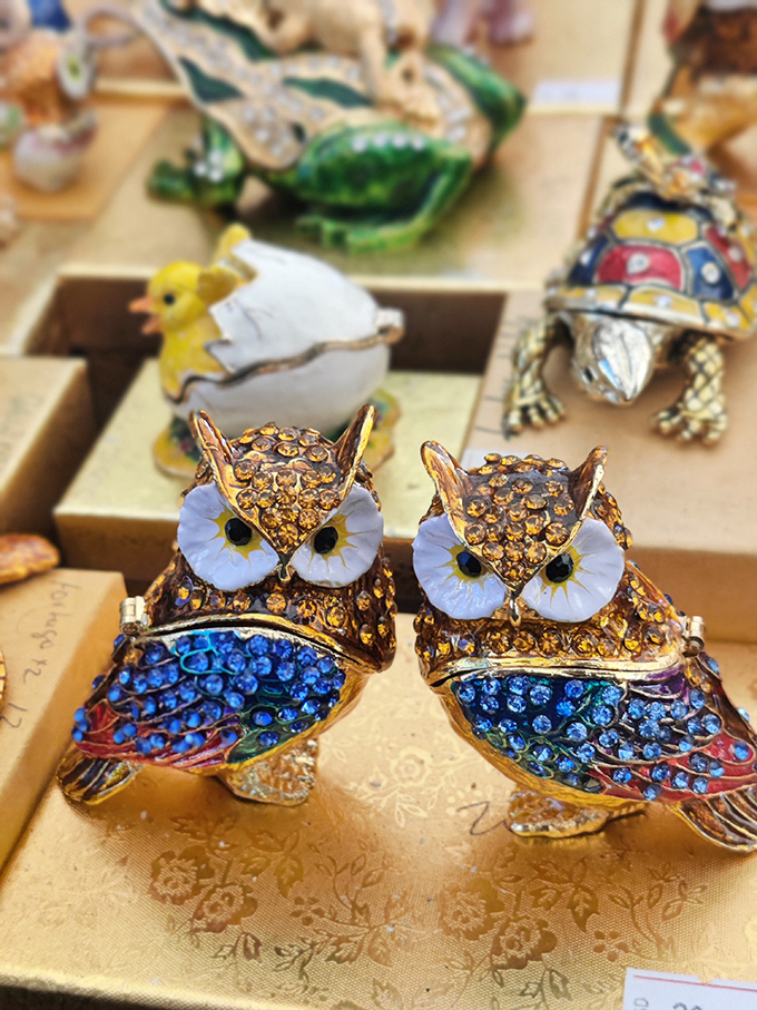 Ceramic owls stand at attention, a parliament of pottery wisdom watching over shoppers with their permanently surprised expressions.