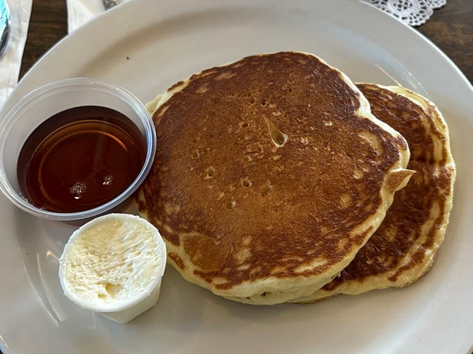 Pancakes so perfectly golden they belong in Fort Knox, with a side of maple syrup that's practically begging to dive in.