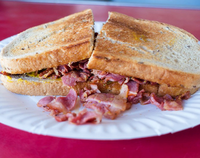 The pastrami sandwich spills forth with pink, smoky goodness. Simplicity elevated to art form on humble toasted bread.