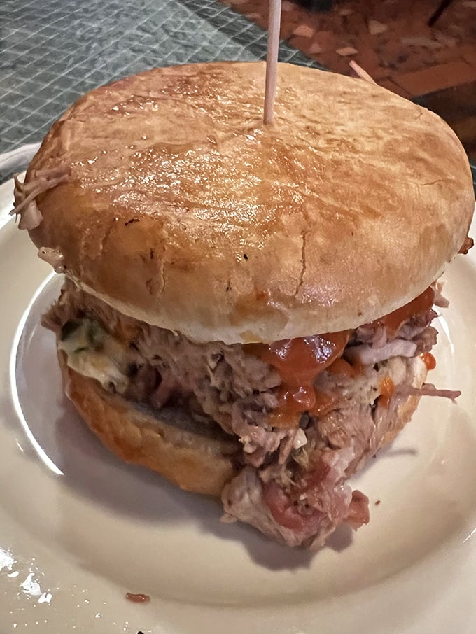 This isn't just a sandwich; it's a monument to patience. Tender pulled pork piled high on a bun, ready to make your day measurably better.