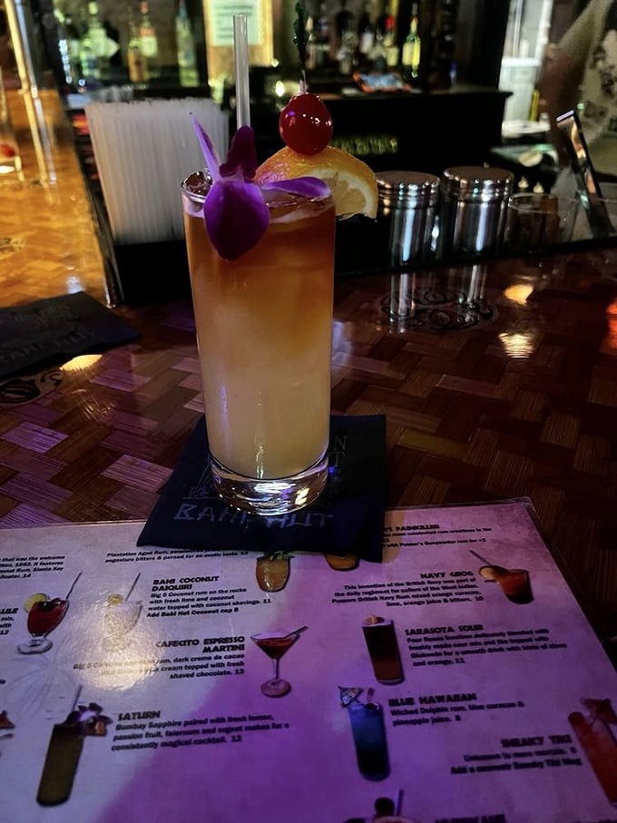 The Saturn cocktail showcases bartender artistry with its elegant presentation and tropical orchid garnish flourish.