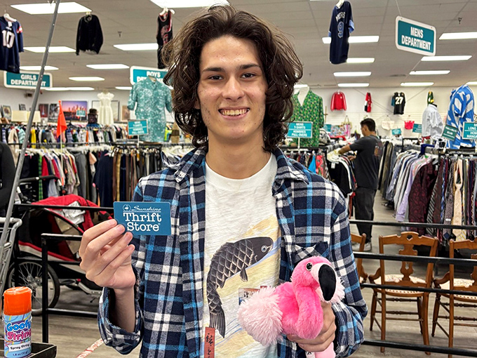 The universal thrift store victory pose: holding your finds with pride. That pink flamingo plush is definitely going home with someone.