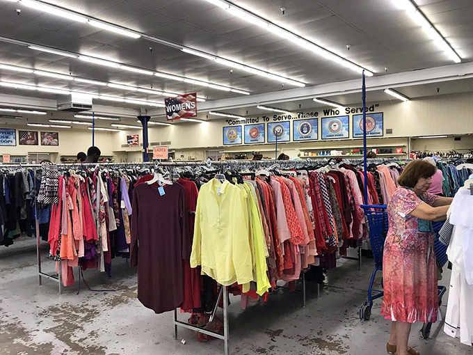 Color-coded clothing racks create a rainbow road of possibilities. That shopper might just find her next favorite outfit hiding between a 90s windbreaker and vintage blouse.