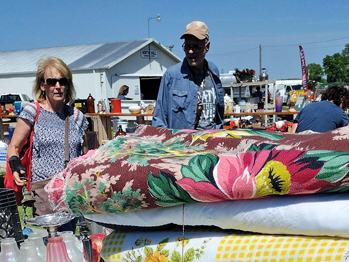 Serious shoppers examine vintage textiles with the concentration of art appraisers. That floral pattern might just be the missing piece to someone's home decor puzzle.