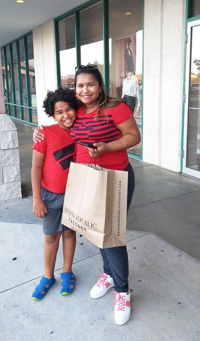 The true face of outlet shopping success—matching outfits and shopping bags filled with treasures that didn't break the bank. Family memories made, style upgraded.