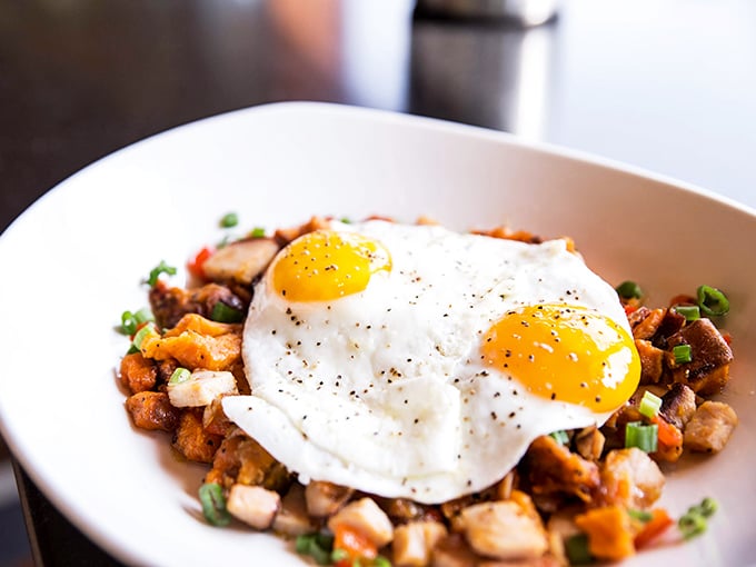 Sunny-side up eggs crown this mountain of savory hash like royal jewels. Breakfast sovereignty at its finest.