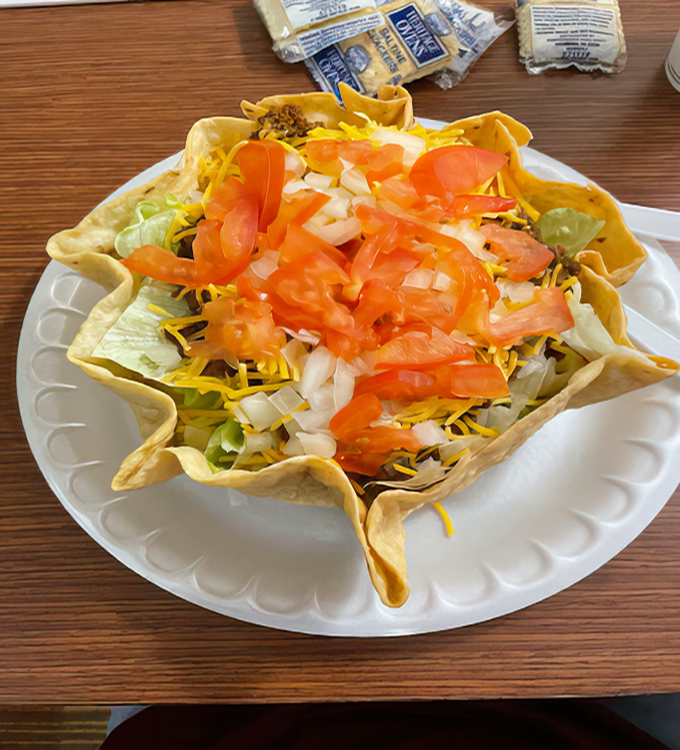 The taco salad arrives in its own edible fortress, a crunchy shell filled with fresh ingredients that somehow makes salad feel like an indulgence.