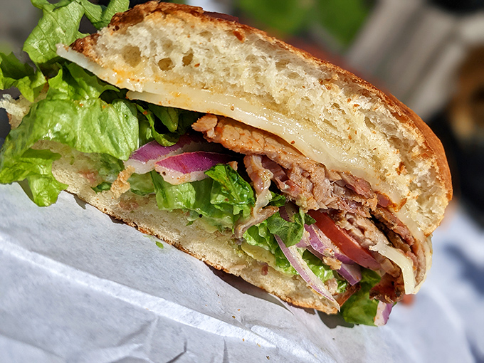 Cross-section perfection: layers of meat, cheese, and fresh vegetables nestled between golden bread&mdash;a sandwich architect's dream come true.