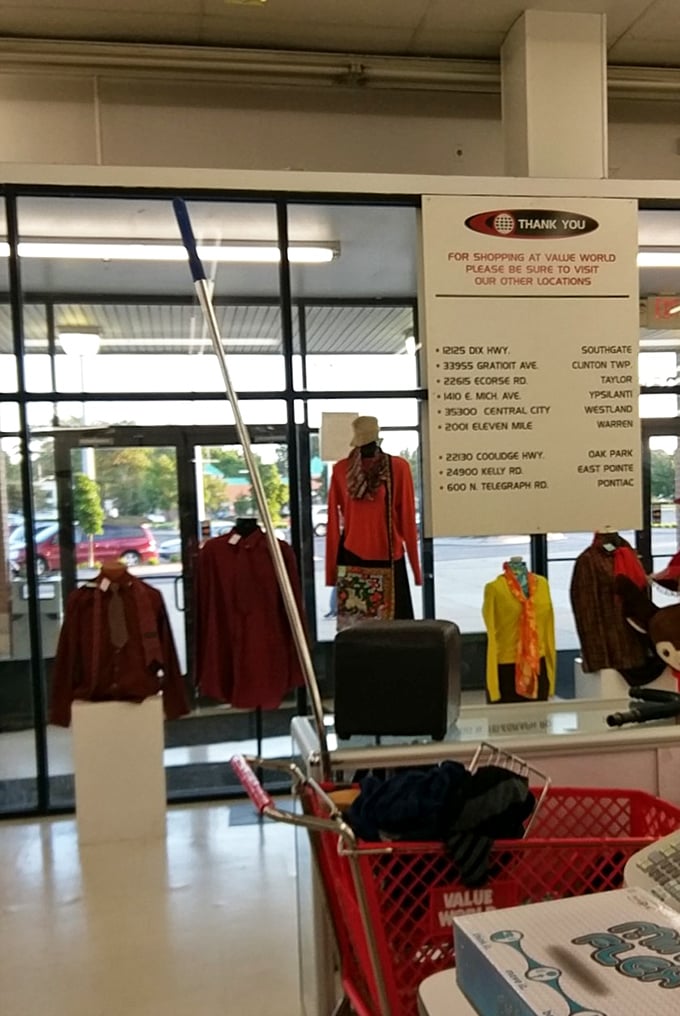 The front window display showcases the day's featured finds, while a sign helpfully points to other Value World locations for the truly dedicated thrifter.