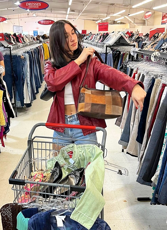 The thrill of the hunt in action &ndash; a shopper examines a vintage handbag while her cart fills with fashion gold.