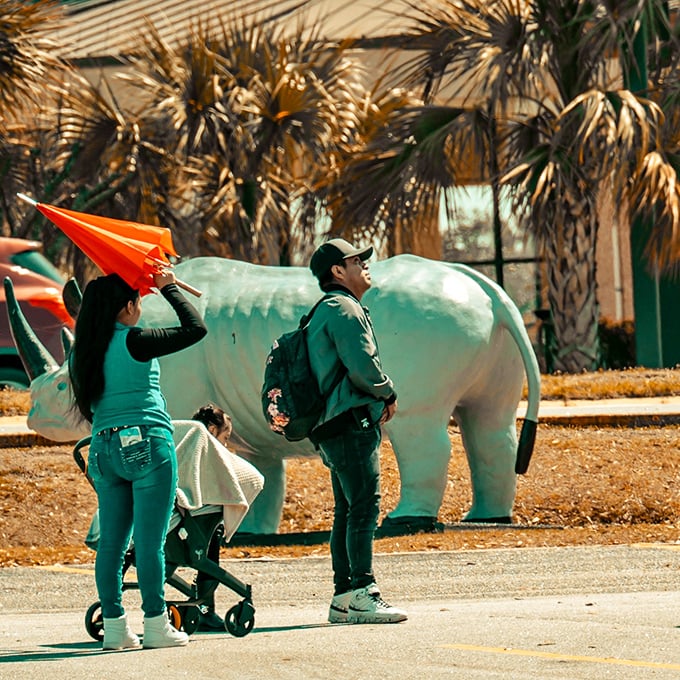 Family fun meets fiberglass fantasy as visitors pose with the green dinosaur that time and good taste forgot.
