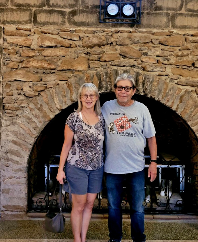Visitors stand framed by a masterfully crafted stone archway, providing scale to this remarkable underground achievement. The architecture invites exploration.
