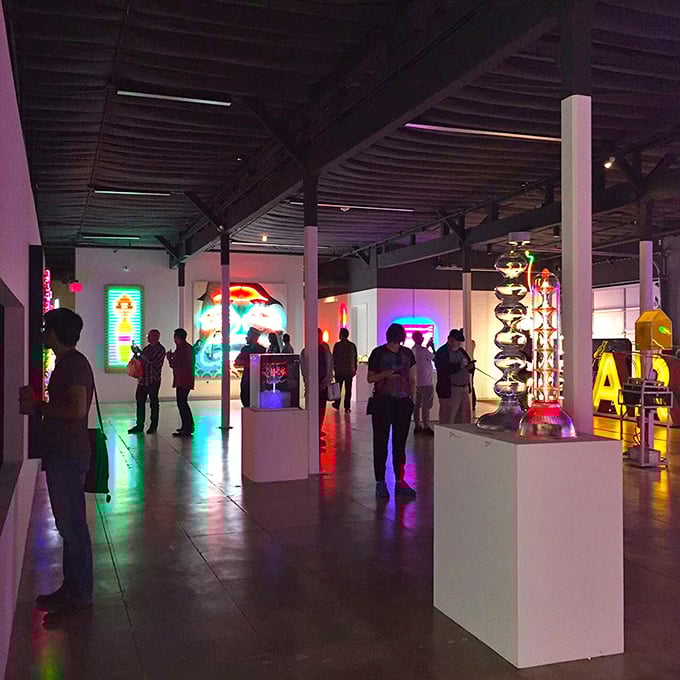 Visitors wander through MONA's electric dreamscape, their faces painted in the technicolor glow of decades past and artistic visions future.