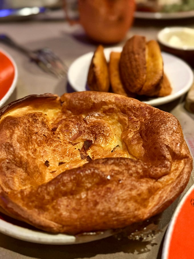 The Yorkshire pudding rises to the occasion, a golden, puffy vessel waiting to be filled with savory jus. Carbs performing their highest calling.