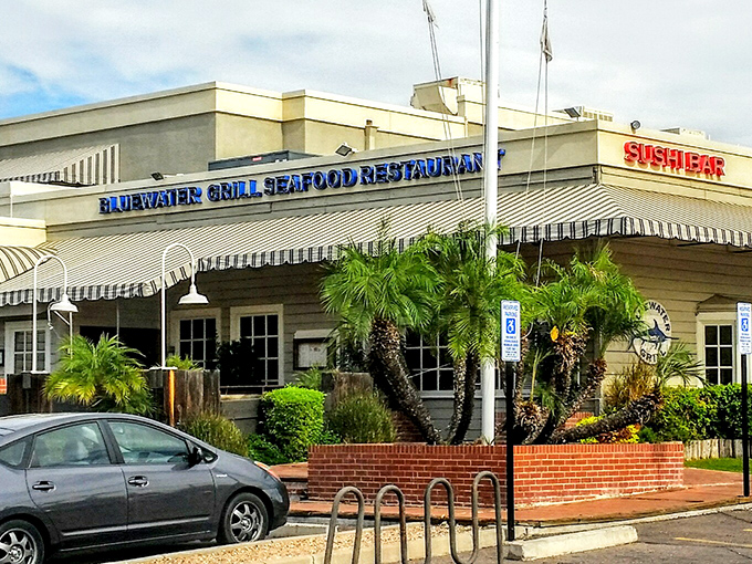 Bluewater Grill's classic seafood restaurant vibe is instantly recognizable. Palm trees and striped awnings set the stage for ocean-fresh delights.