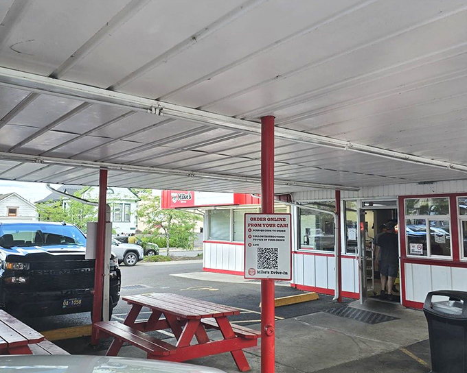 Simple pleasures under a humble canopy. That classic red picnic table says "sit a spell" while the order window promises satisfaction is just minutes away.