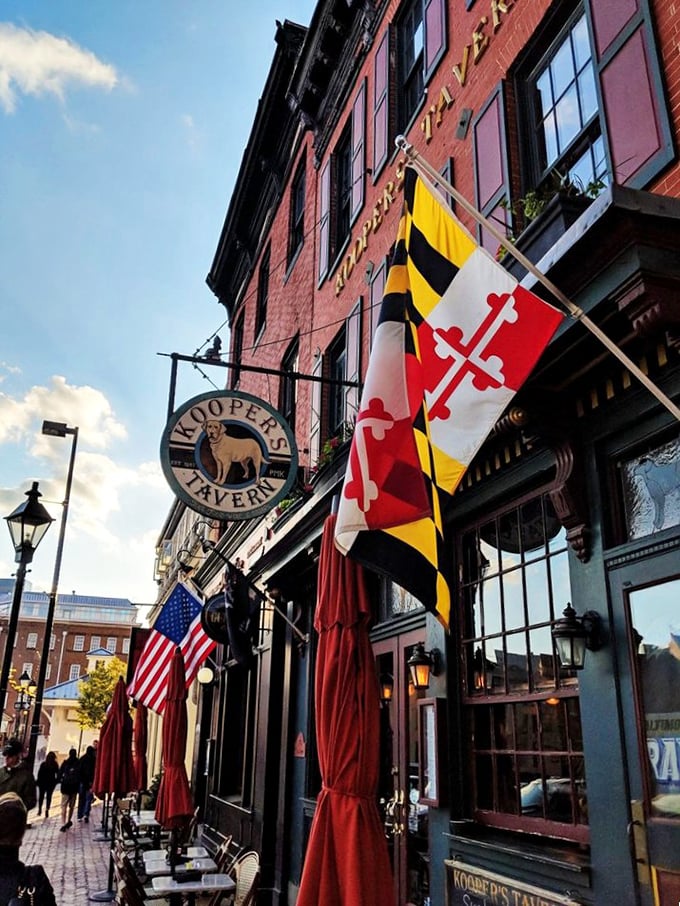Maryland pride flies high outside Kooper's brick facade. Historic charm meets modern burger mastery on Baltimore's cobblestone streets.