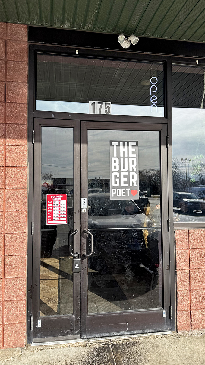 Clear signage and business hours posted for burger enthusiasts. The Burger Poet's minimalist entrance lets the food do the talking.