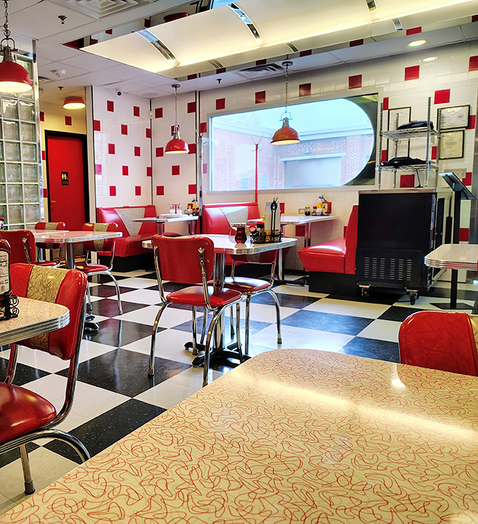 The classic diner tableau: red chairs inviting you to sit, tables waiting for elbows, and pendant lights that make everyone look like they're in a Tarantino film.