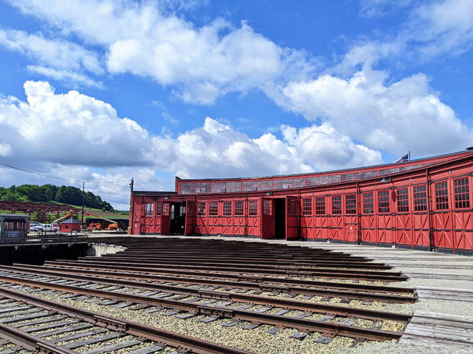 The vibrant red Age of Steam Roundhouse stands as a monument to railroad history, where vintage trains rest like sleeping giants waiting for their next journey.