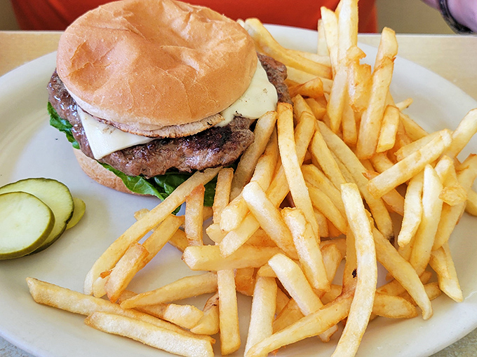 This isn't just any burger—it's the kind that requires a strategic approach. Note the pickle slices standing by, ready to cut through that beautiful beef richness.