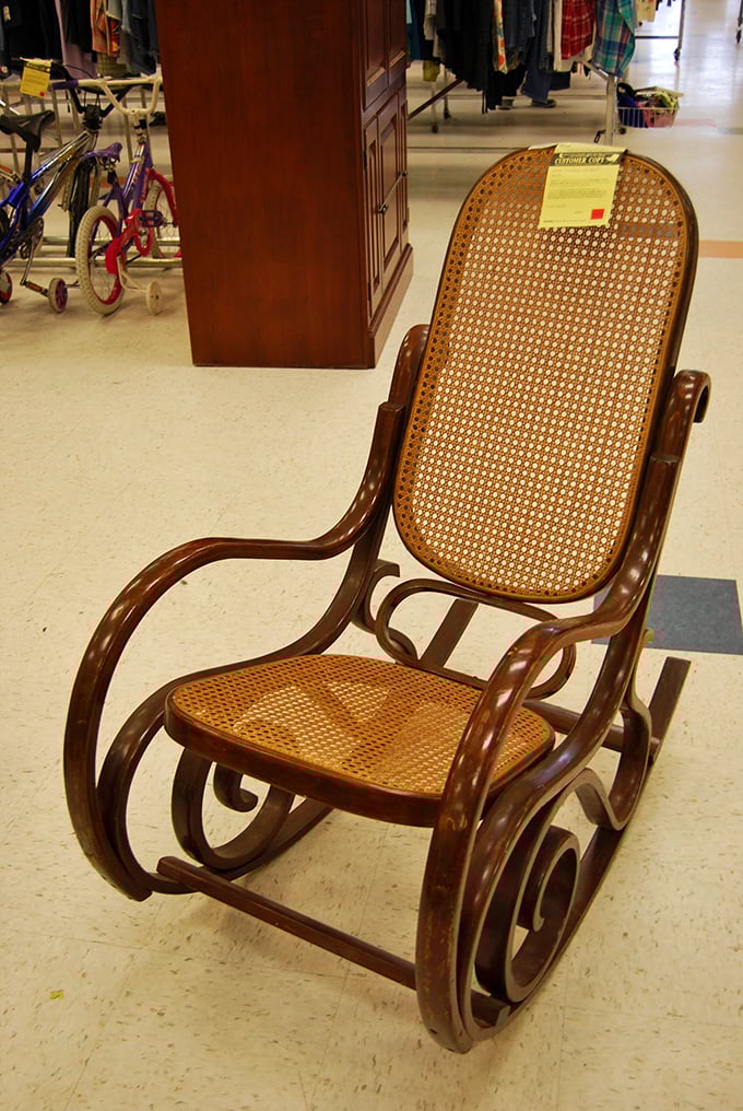 A vintage cane rocking chair stands sentinel, waiting for its next owner. Grandmother-approved comfort with hipster-approved authenticity.
