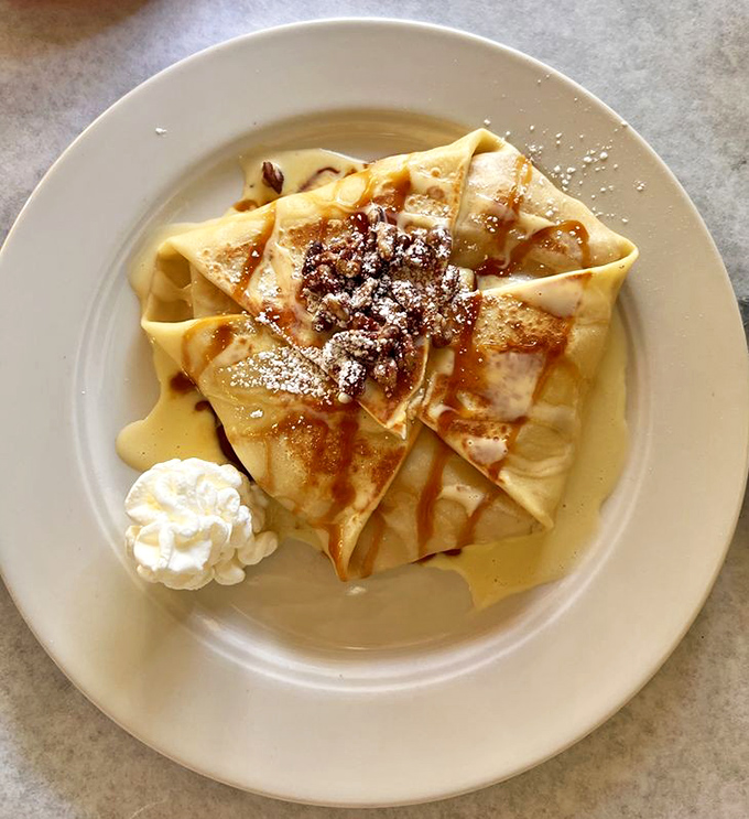 These crepes have folded themselves around warm apples with the confidence of a Parisian who knows they're well-dressed. That dollop of cream is the perfect accessory.