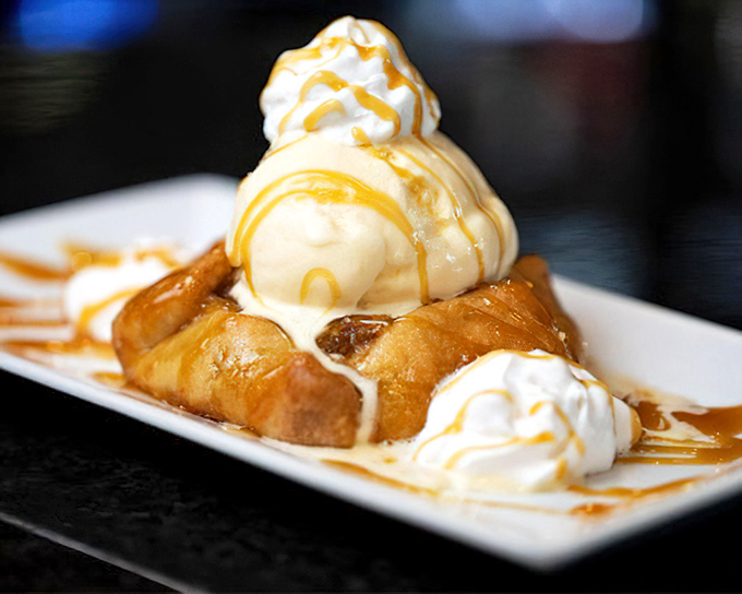 Dessert architecture at its finest&mdash;vanilla ice cream crowning golden-fried apple tarts, all drizzled with caramel that cascades down like sweet, edible lava.