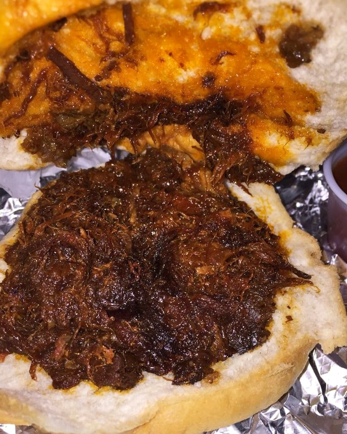 This BBQ pork sandwich isn't messing around&mdash;dark, rich sauce clinging to tender shredded meat on that perfectly steamed bun. Napkins required, regrets impossible.